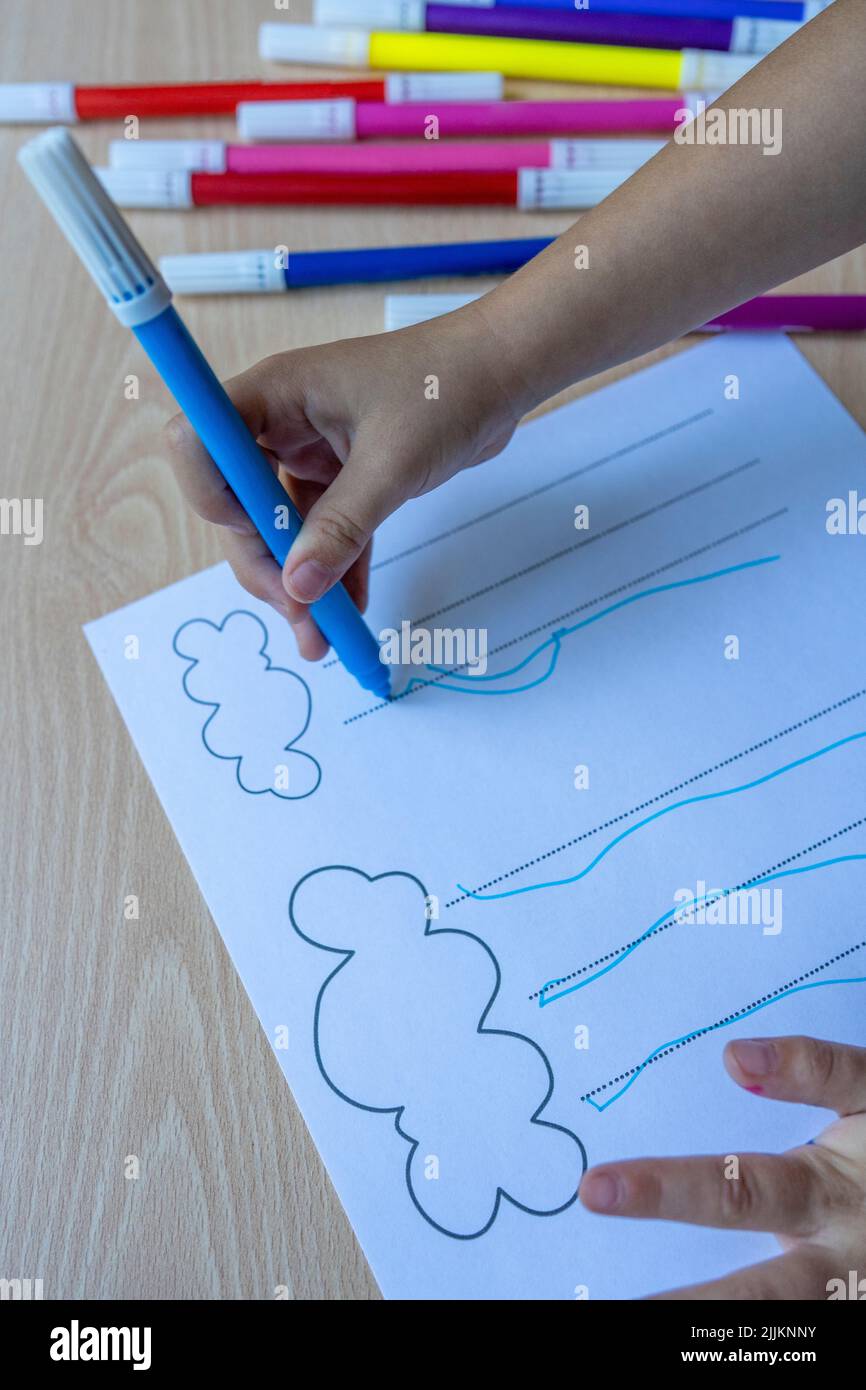 close-up of a little girl's hands doing fine motor skills exercises ...