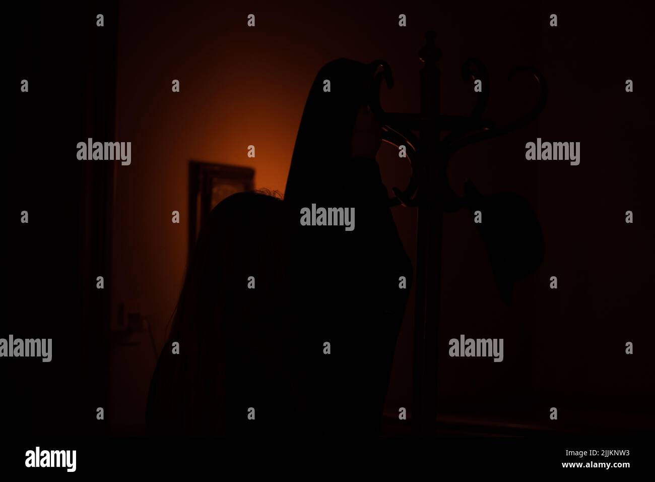 Shadows of objects in the dim light in front of an orange light Stock ...