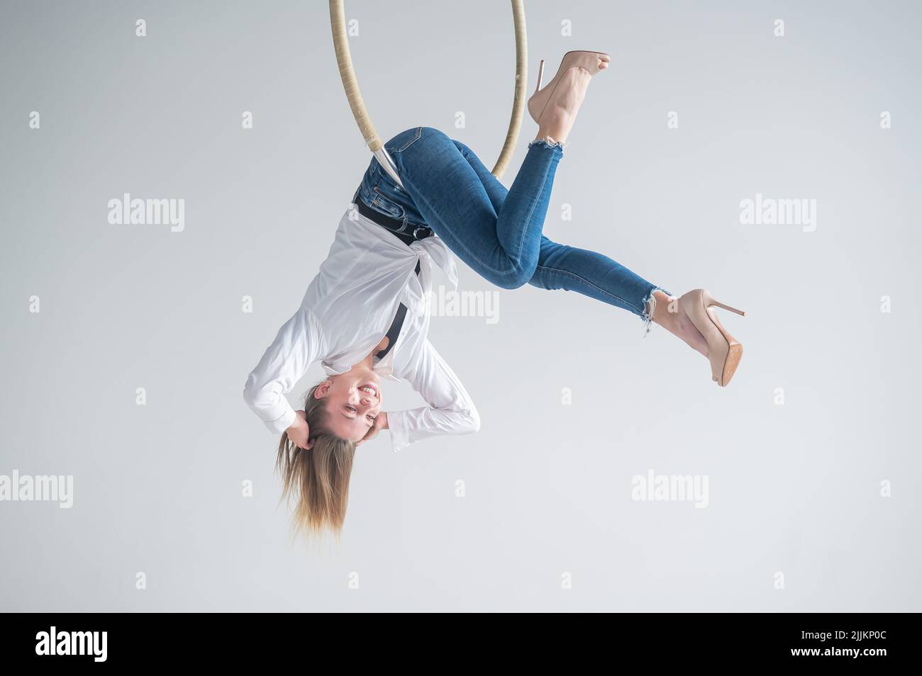 Caucasian woman in casual clothes on an aerial hoop Stock Photo - Alamy