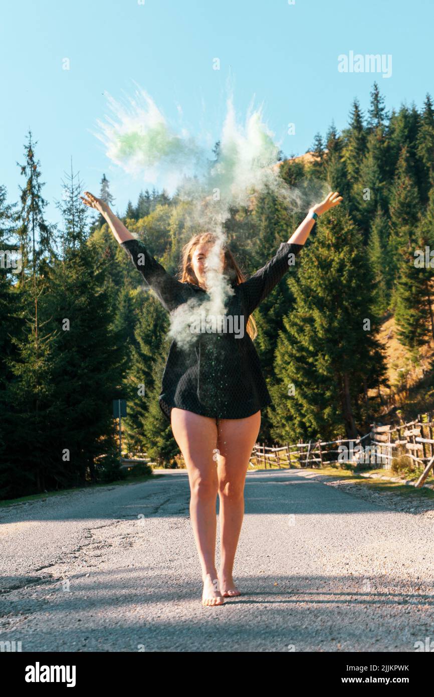 A young Caucasian female splashing powder during a photoshoot in the ...