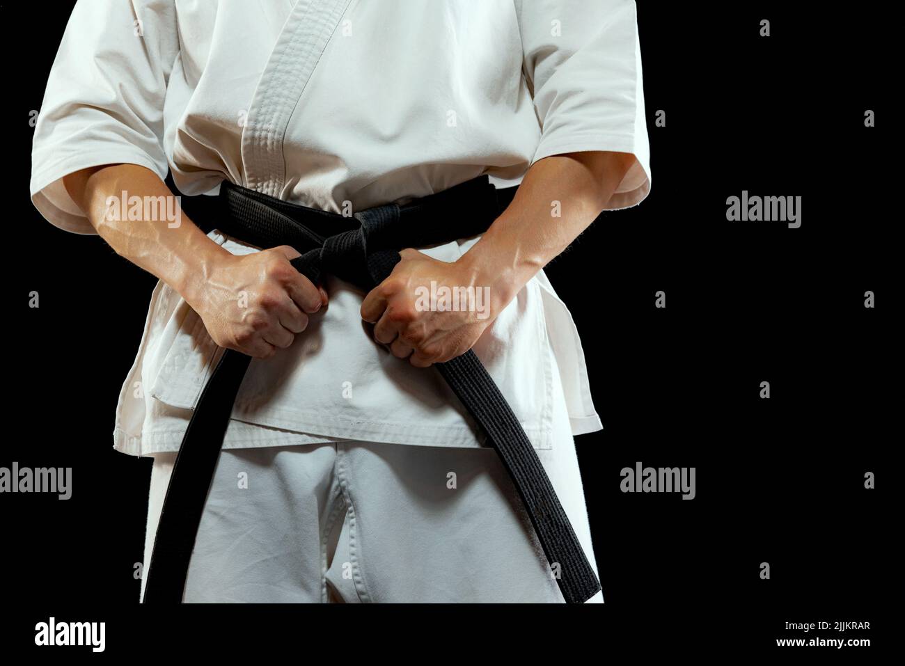Cropped image of male karate fighter in white kimono and black belt in ...
