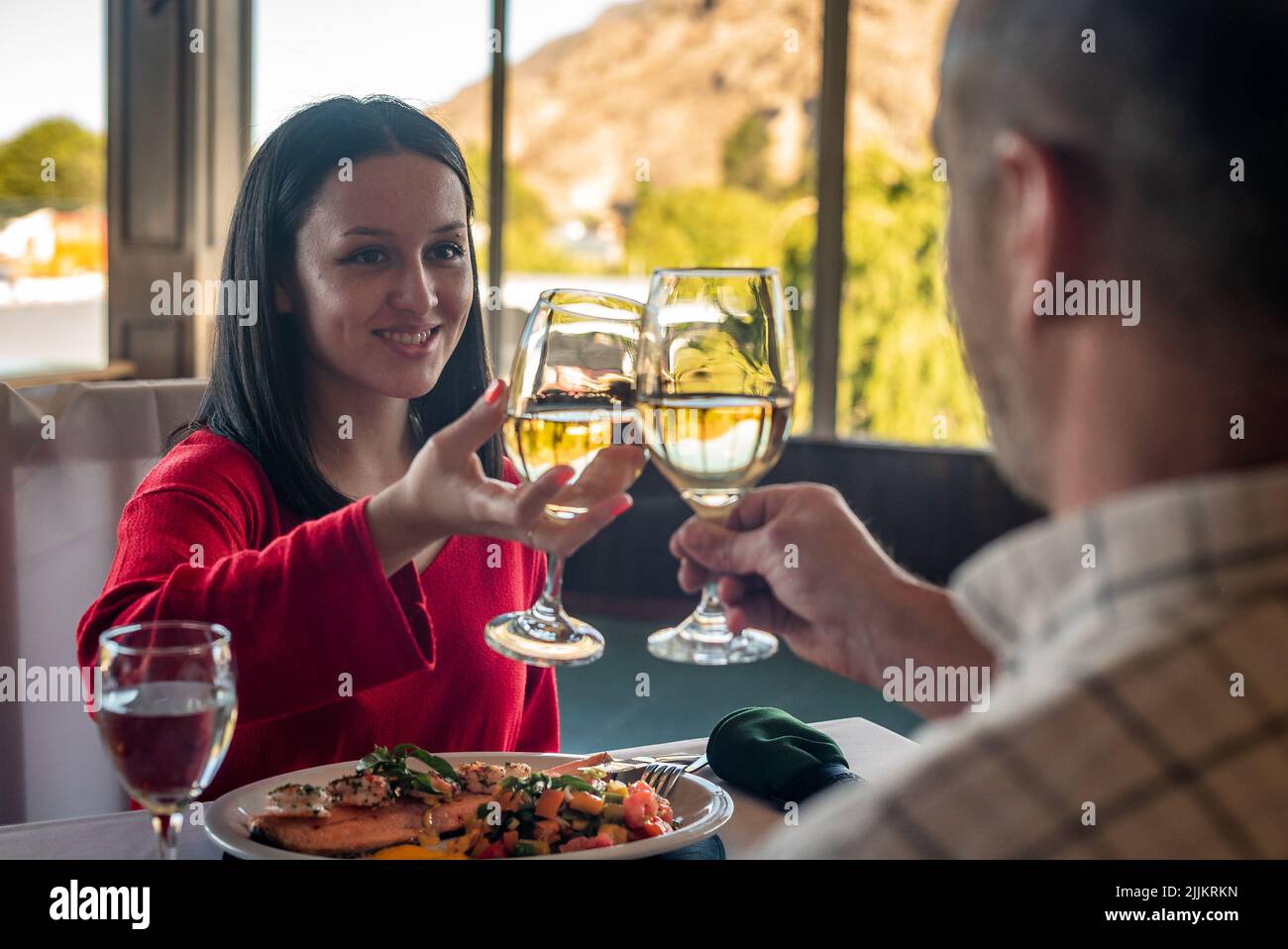 A couple having dinner in an exclusive restaurant, drinking white wine in Patagonia, Argentina ...