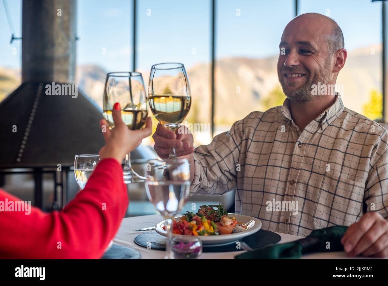 A couple having dinner in an exclusive restaurant, drinking white wine in Patagonia, Argentina ...