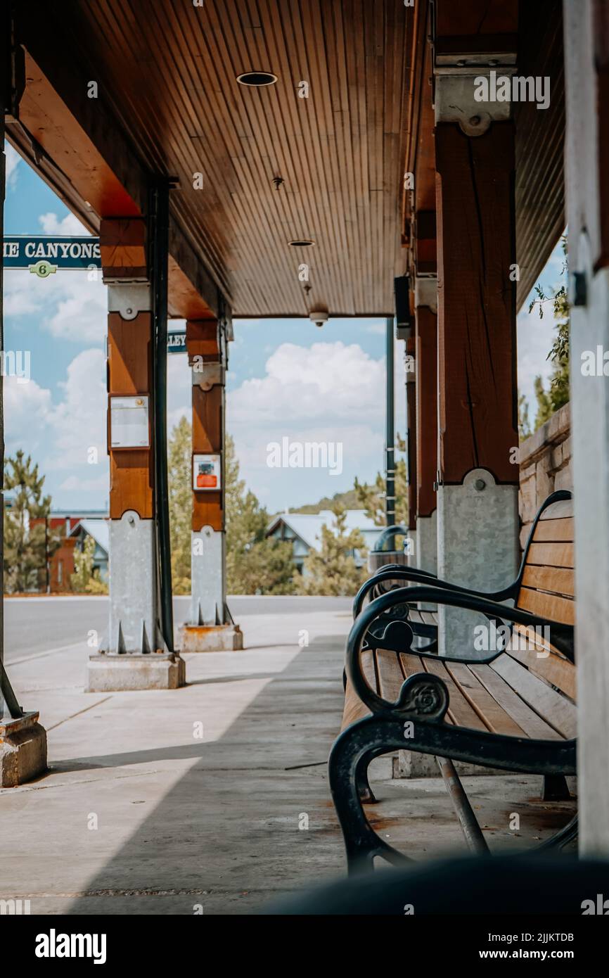 A vertical shot of benches in a bus station under the bright sunlight ...