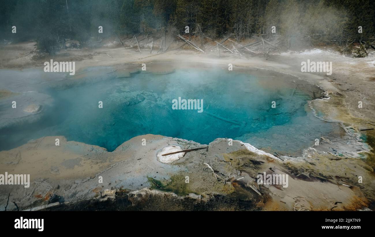 A view of Sapphire Pool with steam in Yellowstone National Park, WY ...