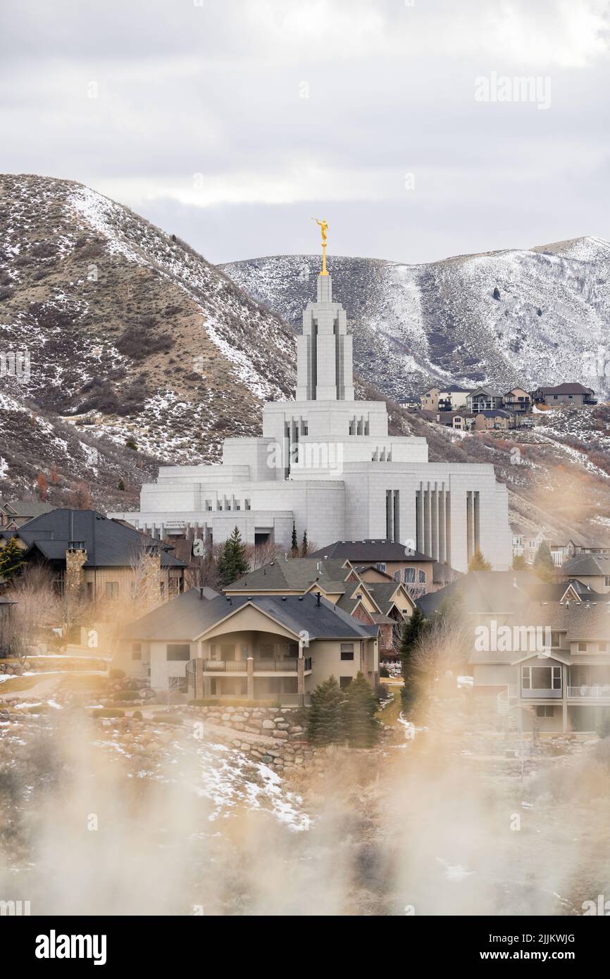 A vertical shot of LDS temple with golden Angel Moroni statue at the ...
