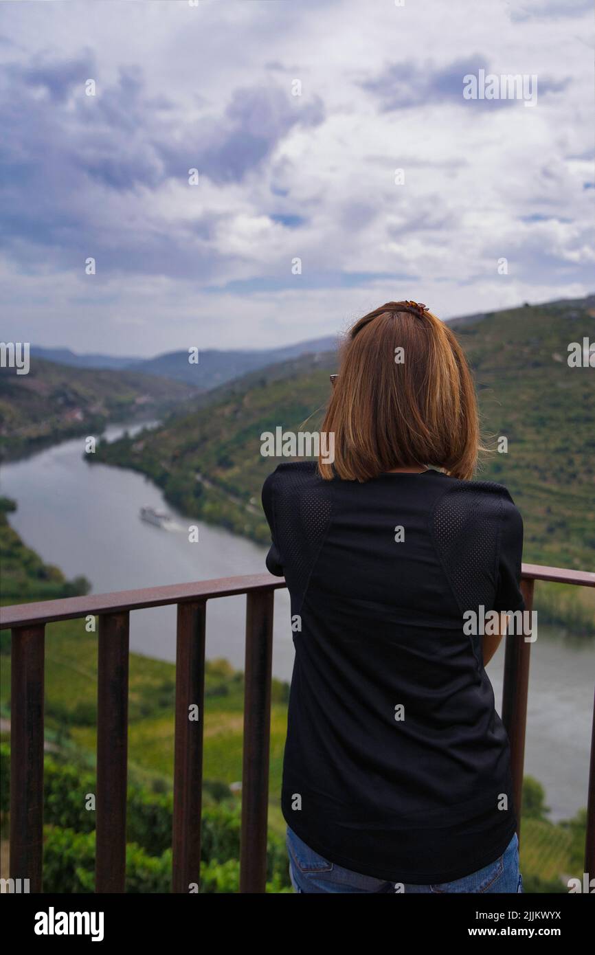 A vertical back view of a female looking at the Douro River Stock Photo ...