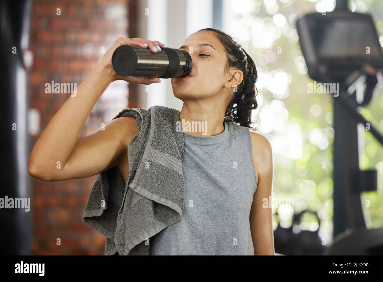That was intense but so worth it. a sporty young woman drinking water ...