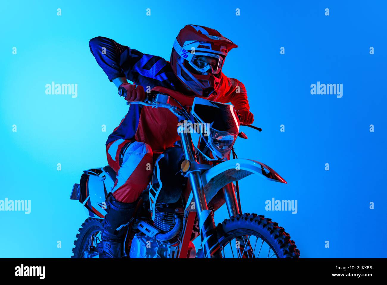 Portrait of young concentrated man, biker riding on cross type ...