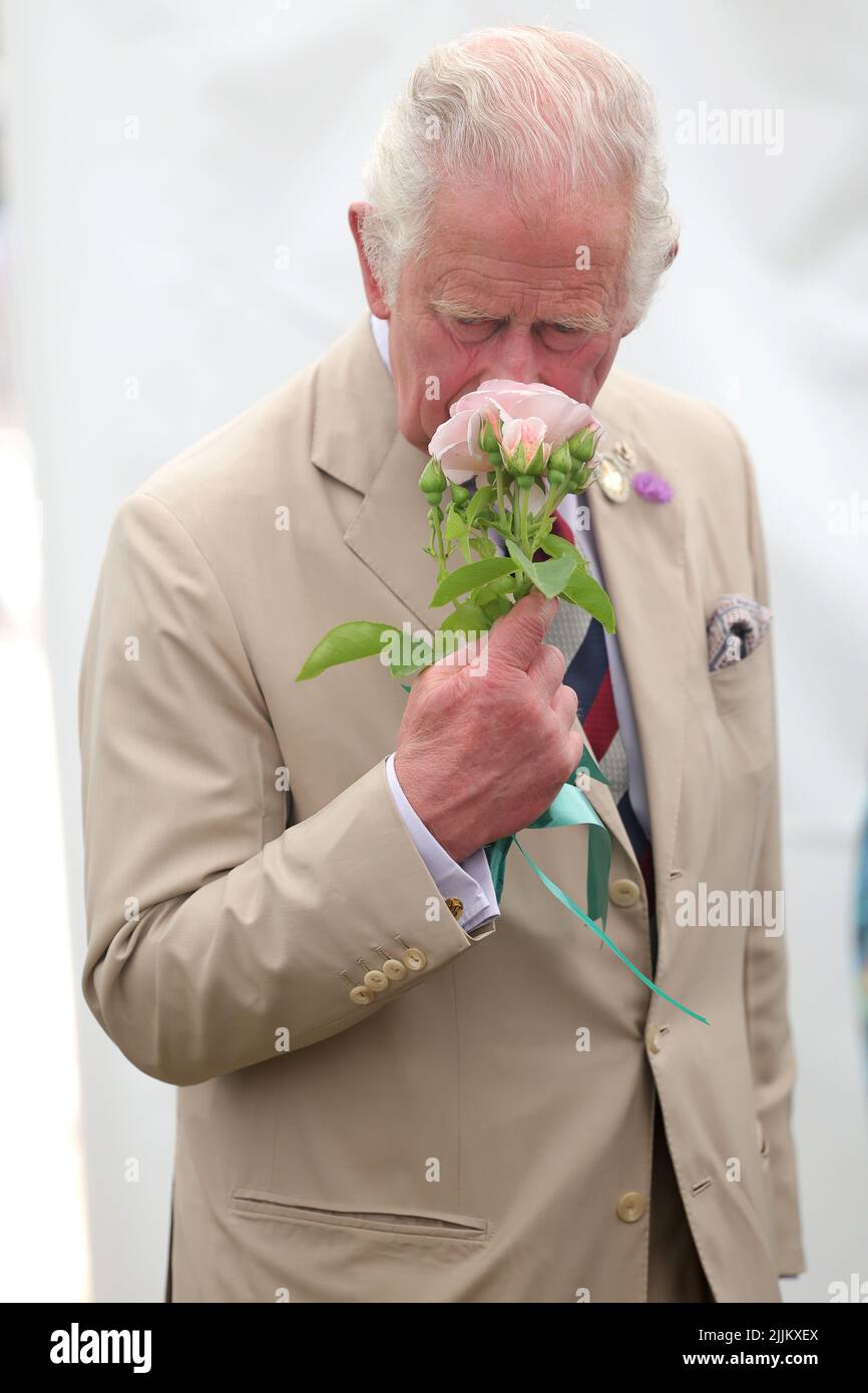 The Prince of Wales smells a flower during his visit and tour of the ...