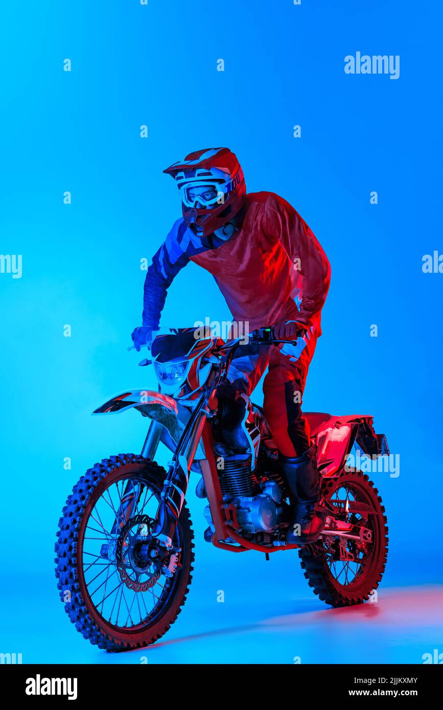 Portrait of young man, biker isolated over blue studio background in ...