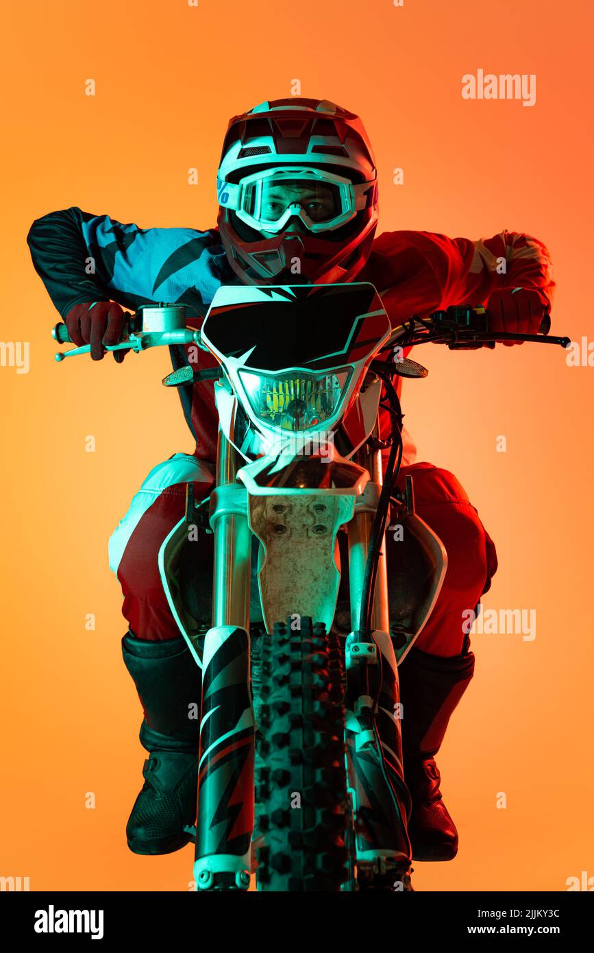 Portrait of young concentrated man, biker developing speed on motorbike ...