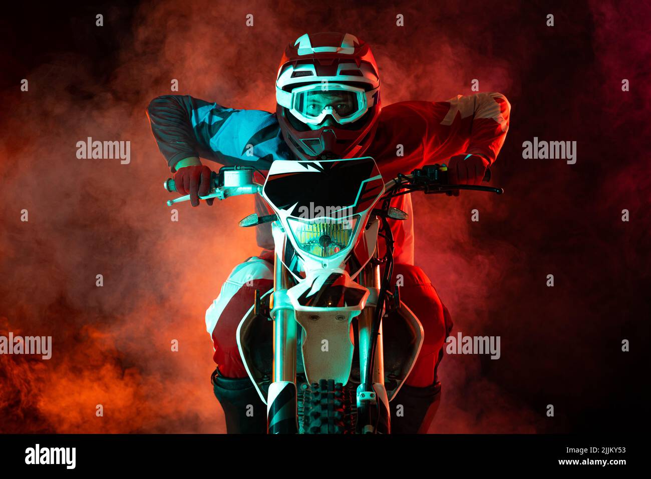 Portrait of young concentrated man, biker developing speed on motorbike ...
