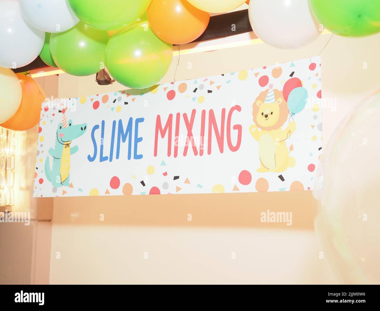 A slime mixing party sign with balloons Stock Photo - Alamy