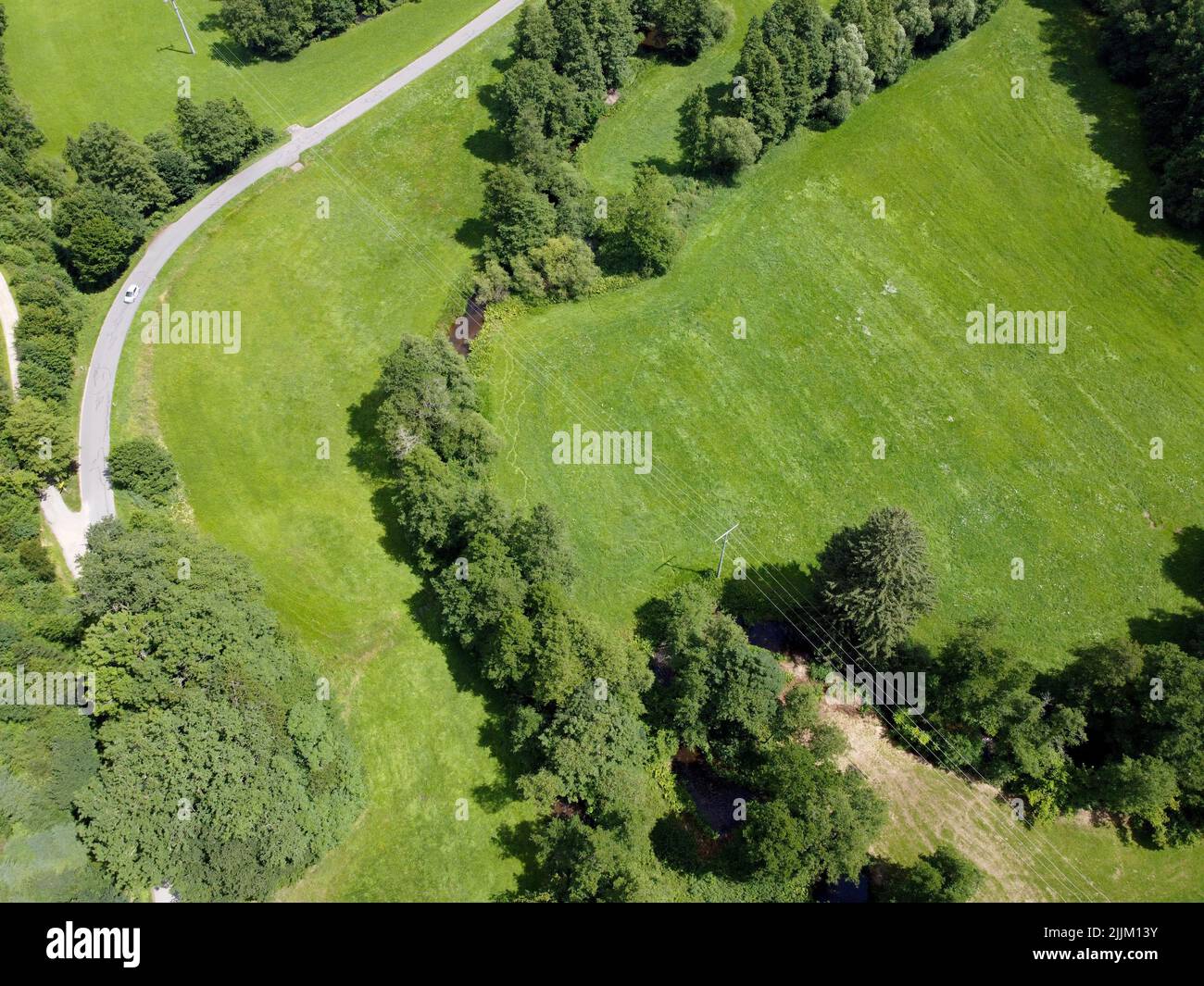 An aerial view of a road winding through green plains Stock Photo - Alamy
