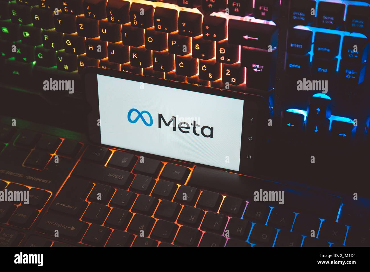 A closeup of a Meta logo on the screen of a mobile phone on a laptop ...
