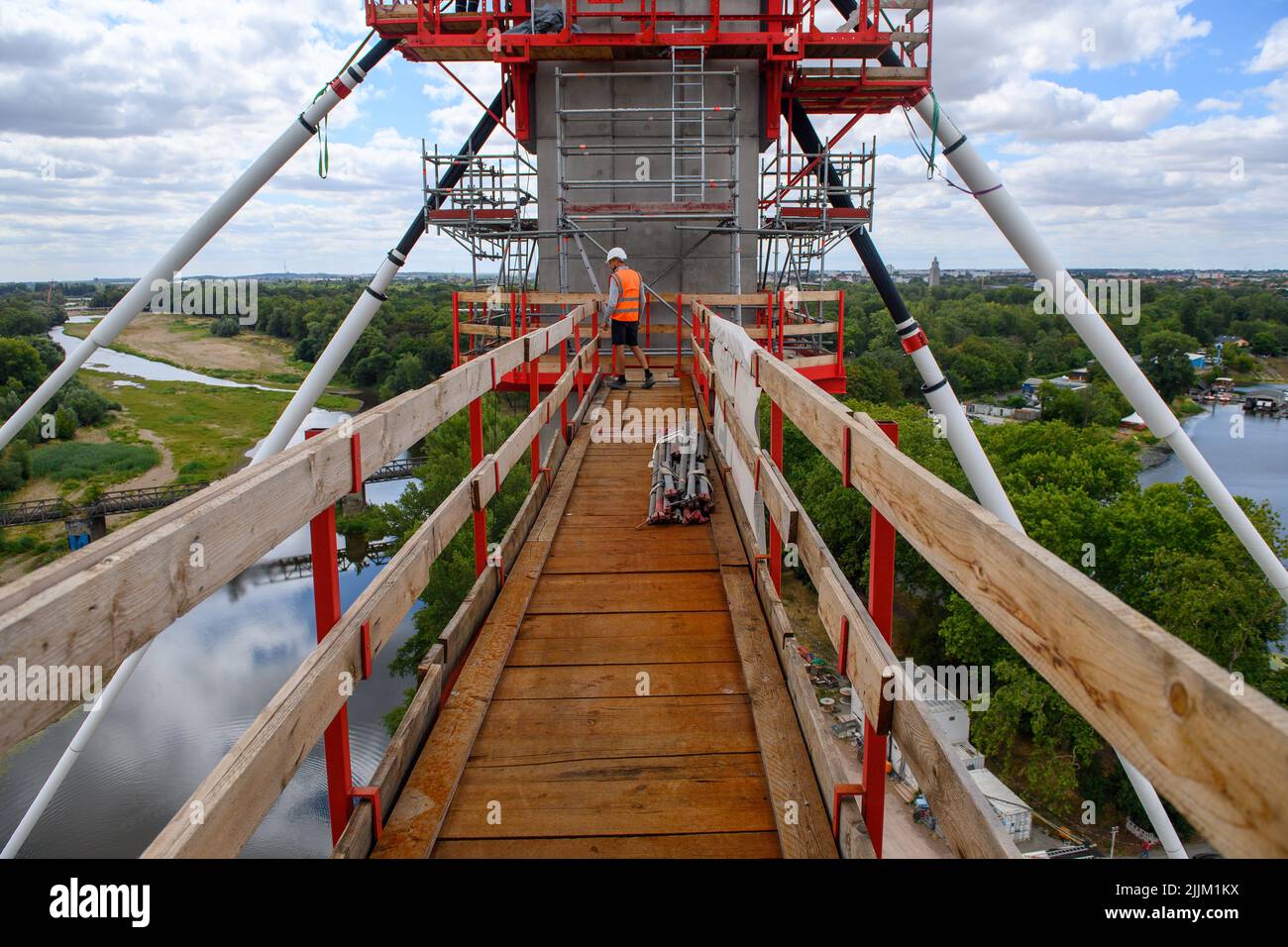 Magdeburg, Germany. 27th July, 2022. A worker stands on a wooden bridge ...