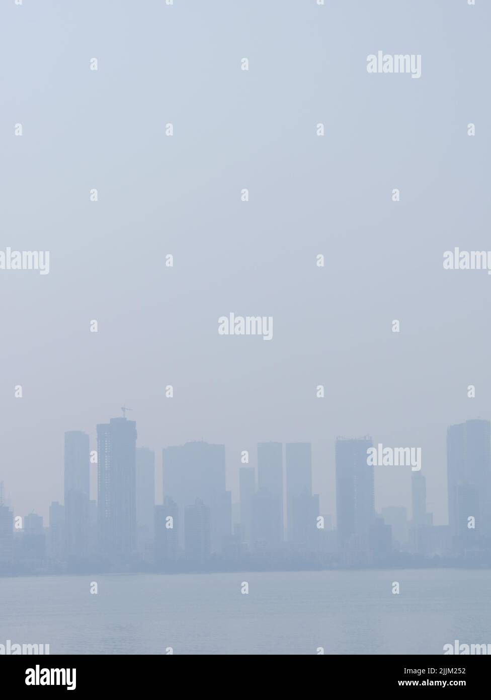 An aerial view of a city with high-rise buildings covered in fog on an ...