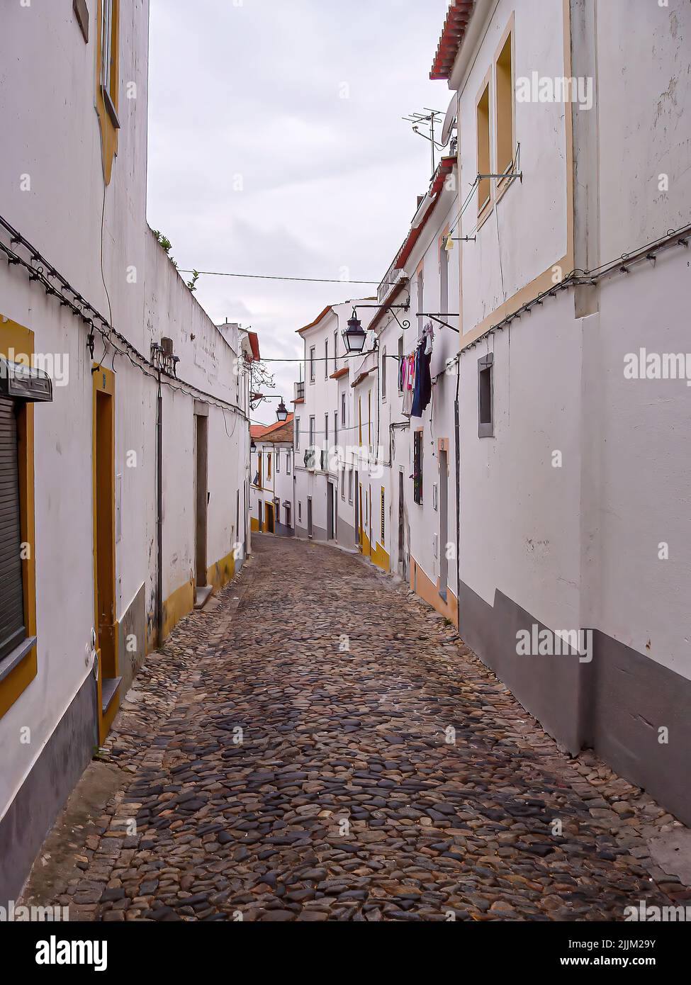 A vertical picture of a road between buildings Stock Photo - Alamy