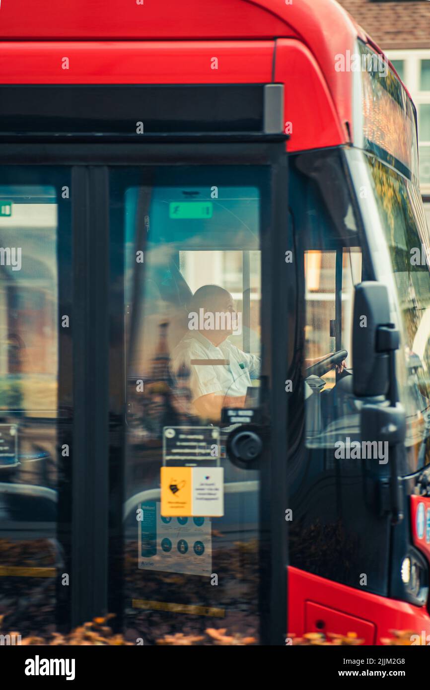 a vertical shot of a bus driver driving a red bus Stock Photo - Alamy