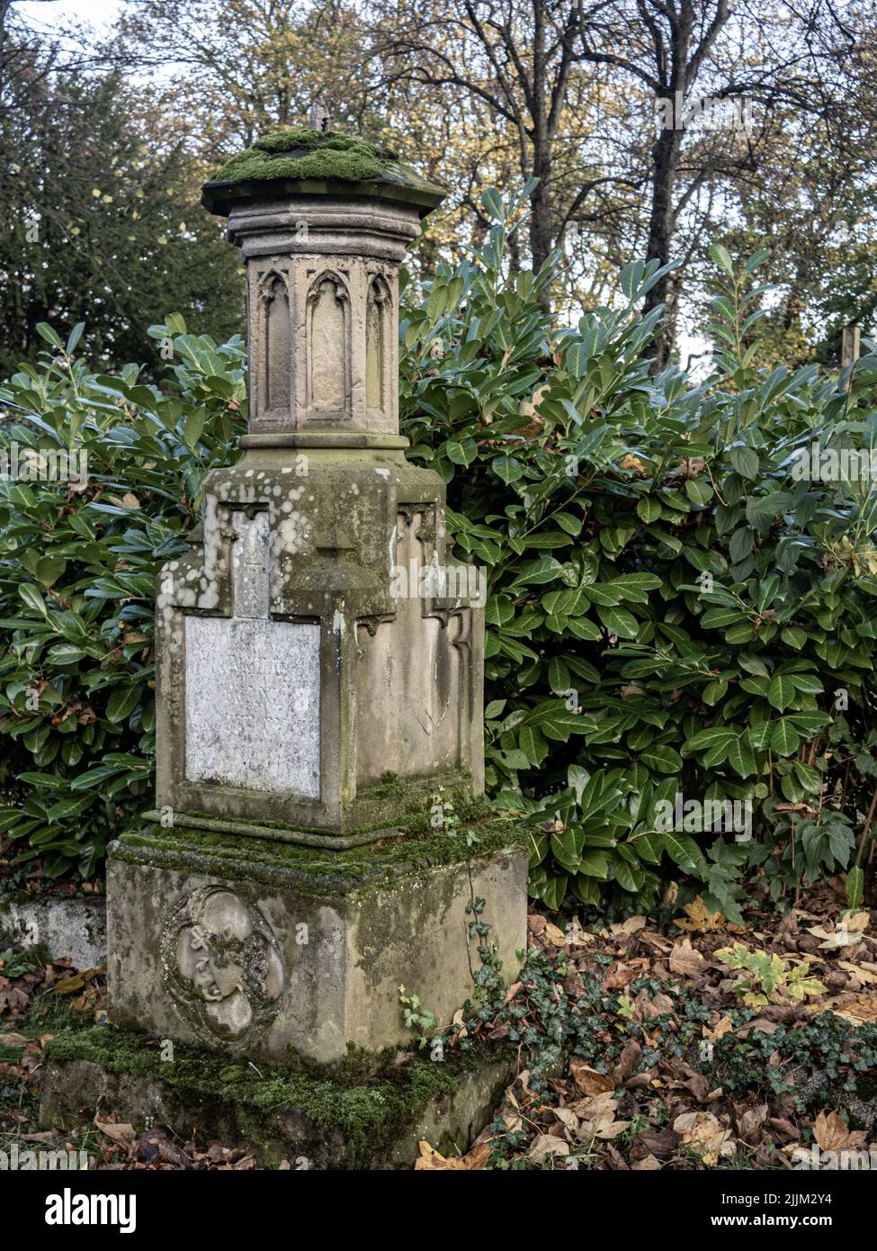 A vertical shot of a mossy grave monument at a cemetery Stock Photo - Alamy