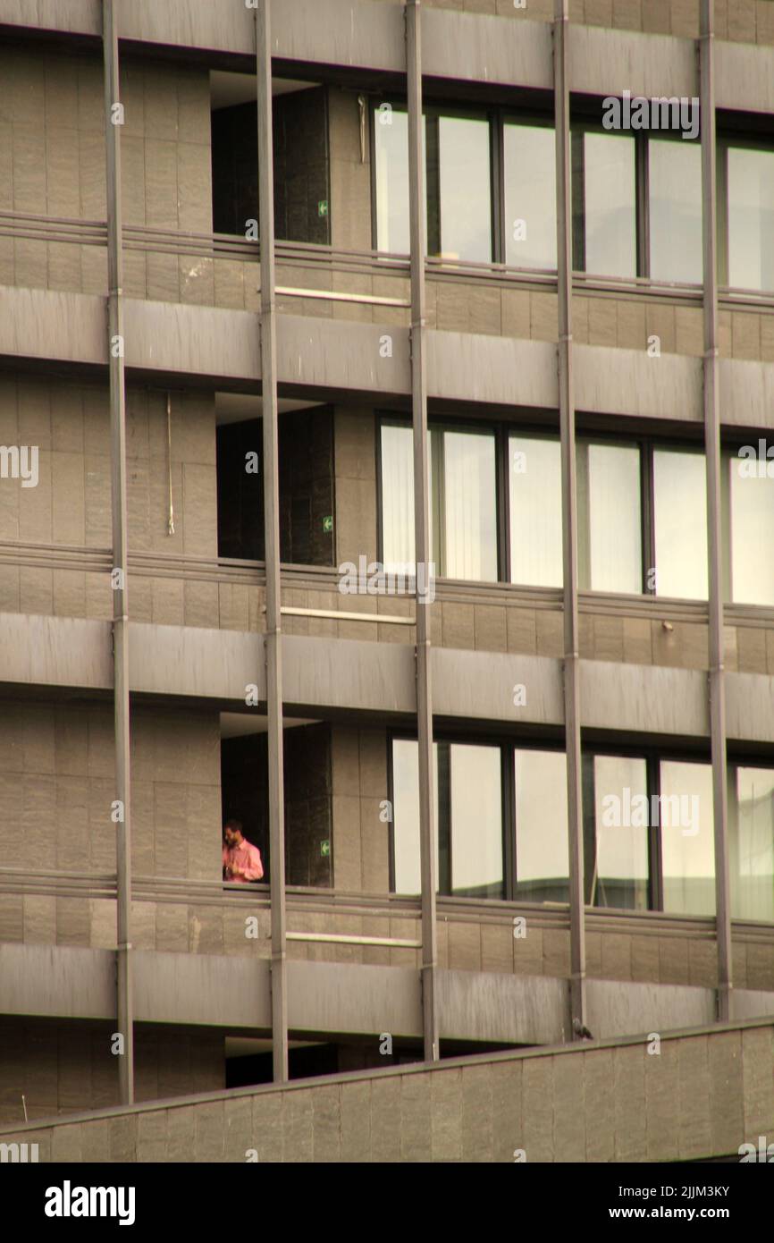 A shot of a building with many glass windows an someone is appearing ...