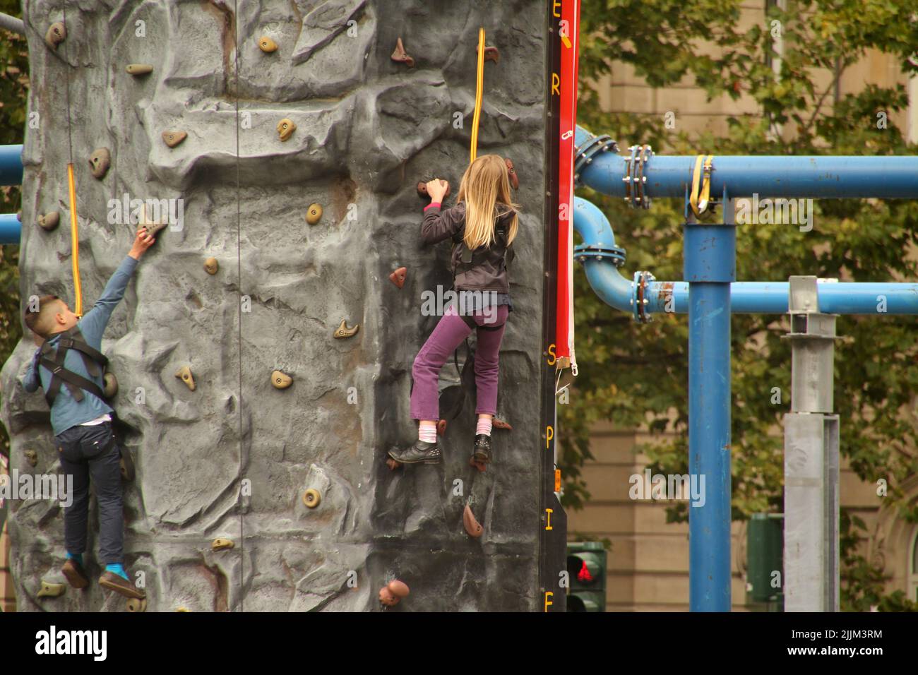 A daylight shot of children climbing on a wall Stock Photo - Alamy