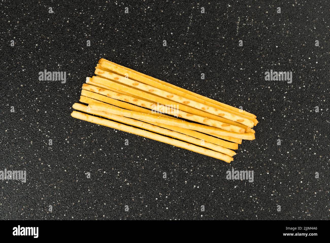 Yellow corn snack sticks side view on a black cutting board Stock Photo ...