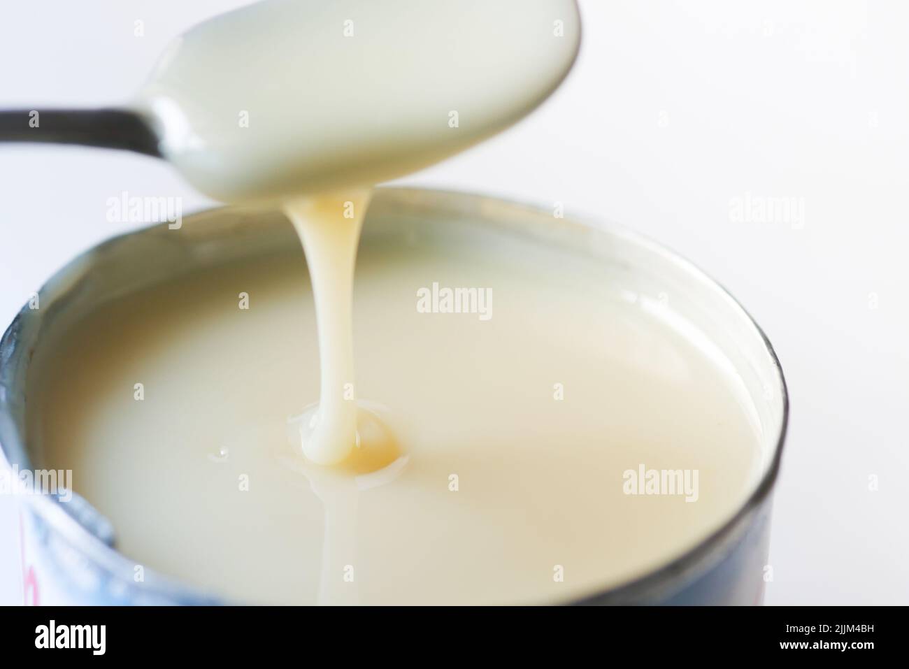 condensed milk in a bowl close up Stock Photo - Alamy