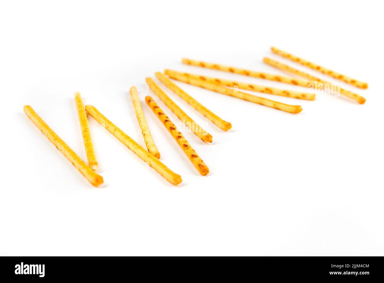Scattered yellow corn snack sticks side view isolated over white Stock ...