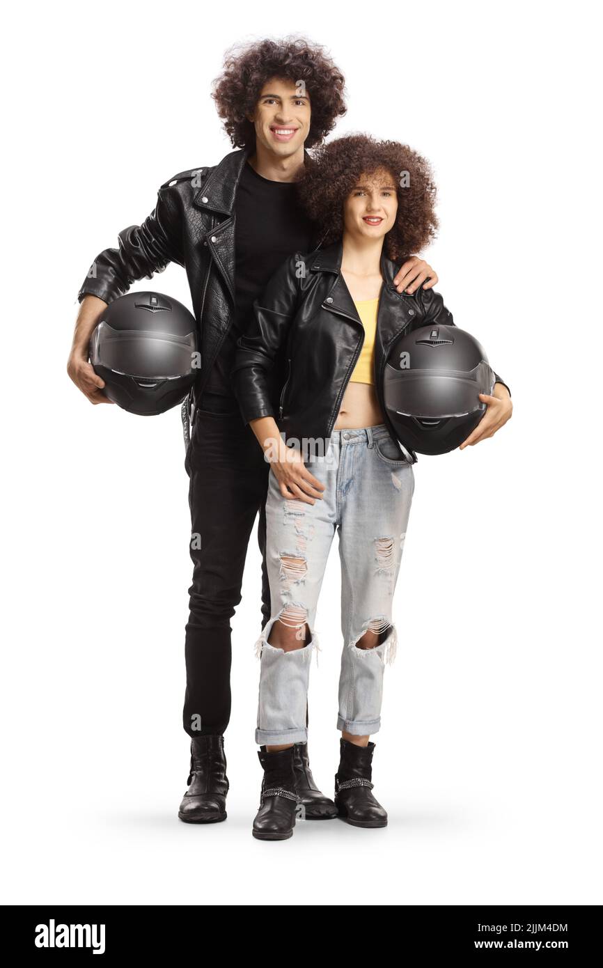 Full length portrait of a young man and woman in leather jackets holding motorbike helmets ...