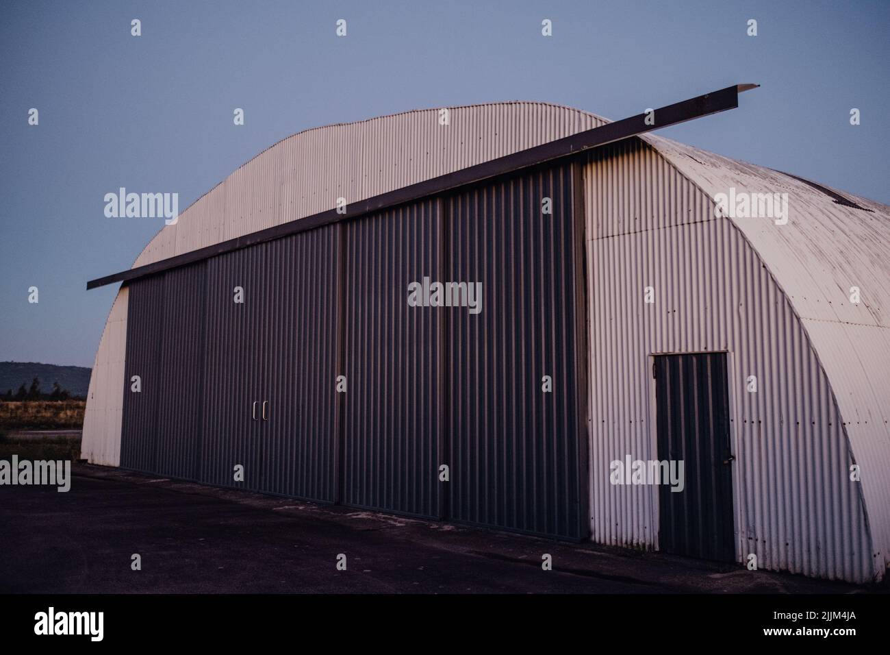 A big metal arched hangar countryside on a blue sky background Stock ...