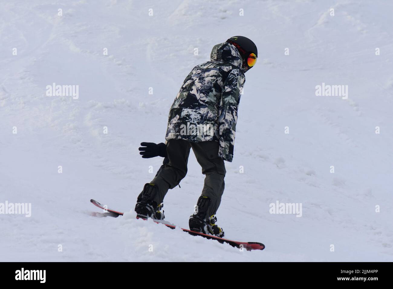 A young man on a snowboard on a slope in the Carpathian Mountains in ...