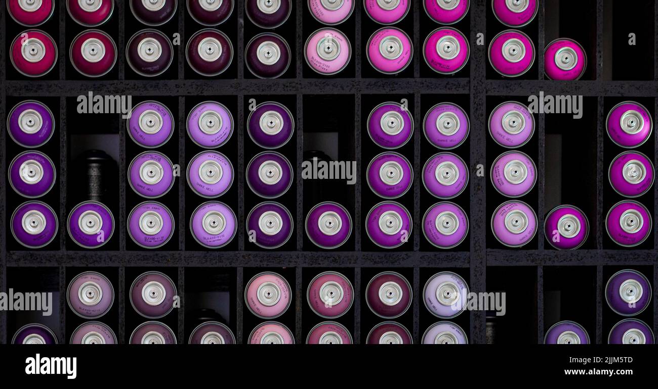 A black rack with cans of purple tone graffiti paints Stock Photo - Alamy