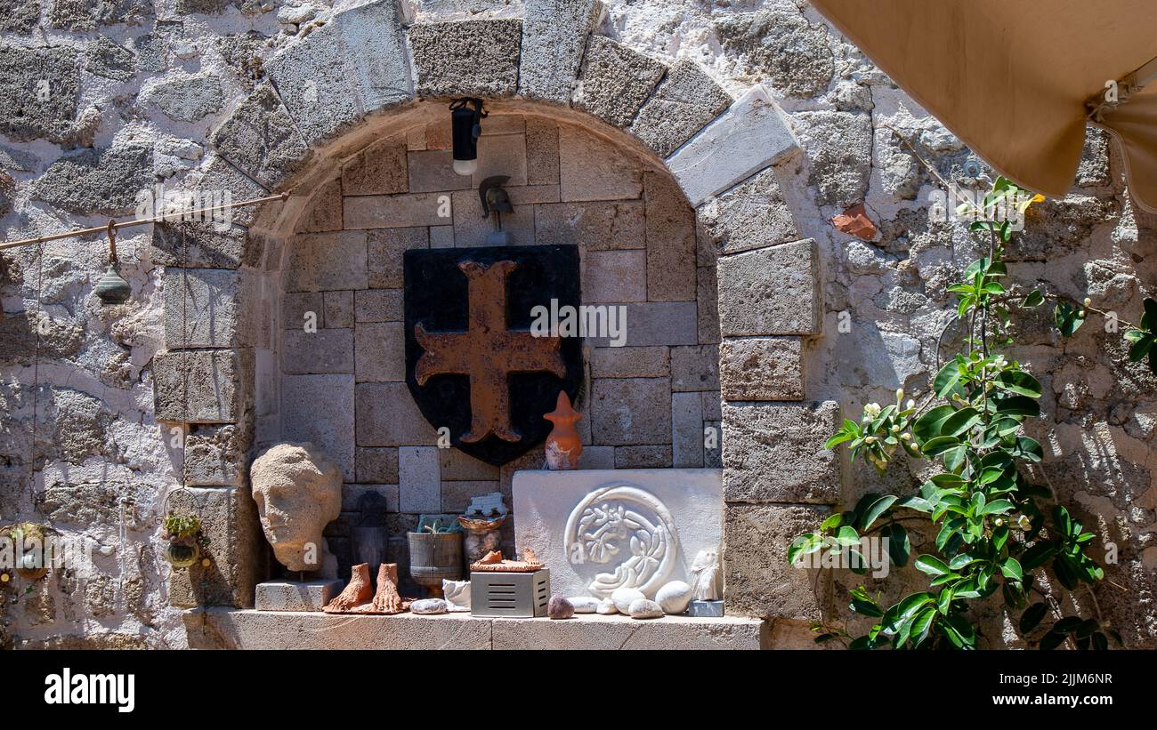 An old monastery with a cross and artifacts in Rhodes, Greece Stock ...