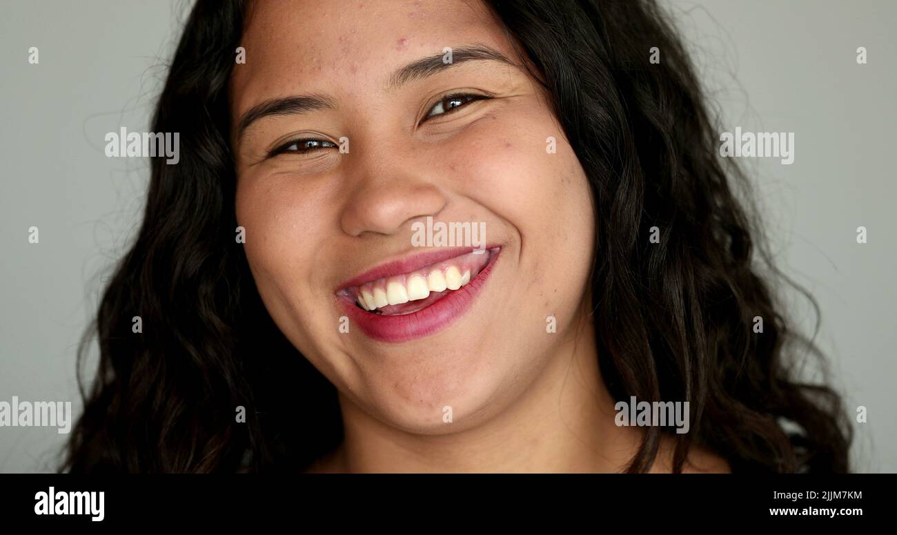 Casual hispanic latina girl looking at camera and touching hair. Close ...