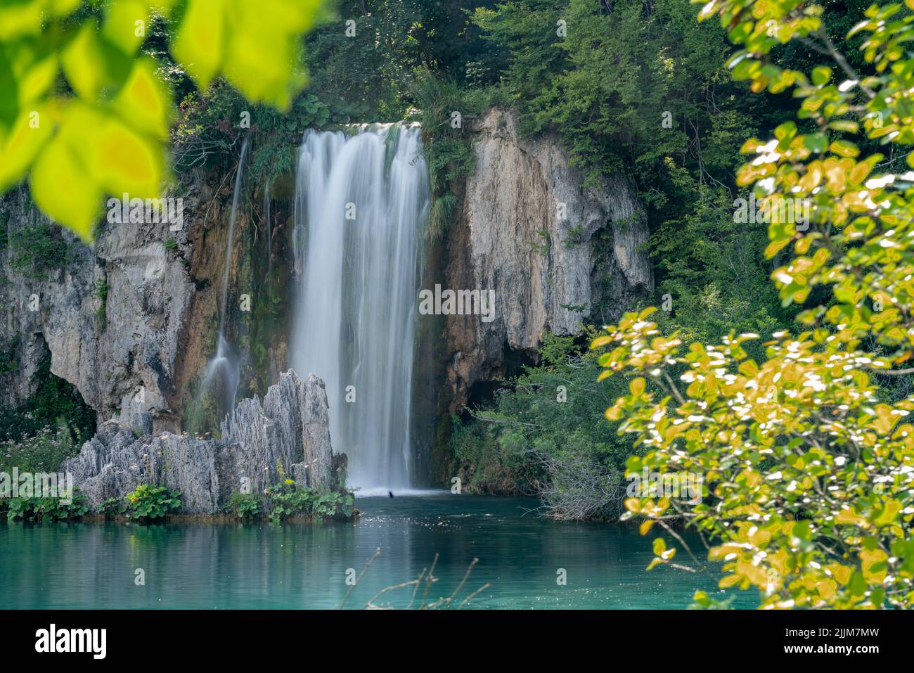 The beautiful waterfall surrounded by green vegetation Stock Photo - Alamy
