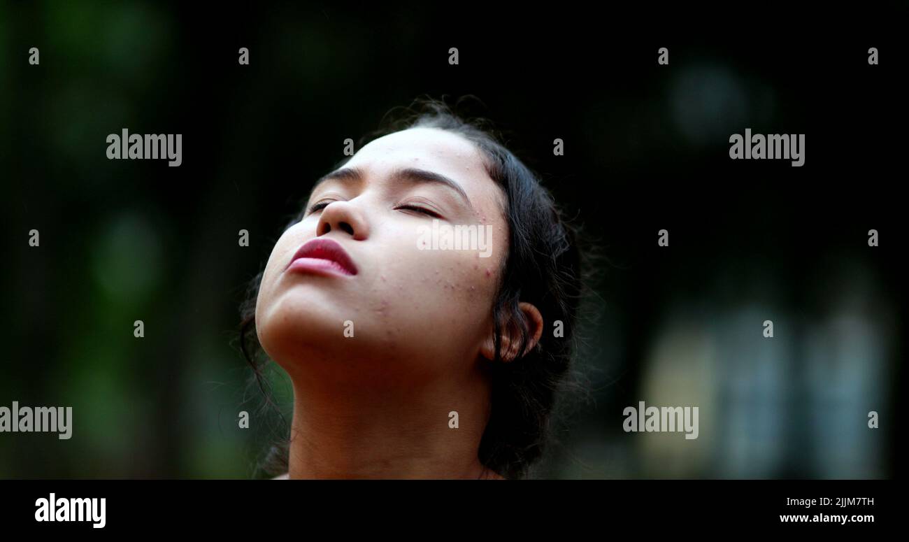 Contemplative young woman closing eyes in meditation. Close-up girl ...