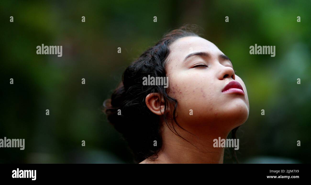 Contemplative young woman closing eyes in meditation. Close-up girl ...