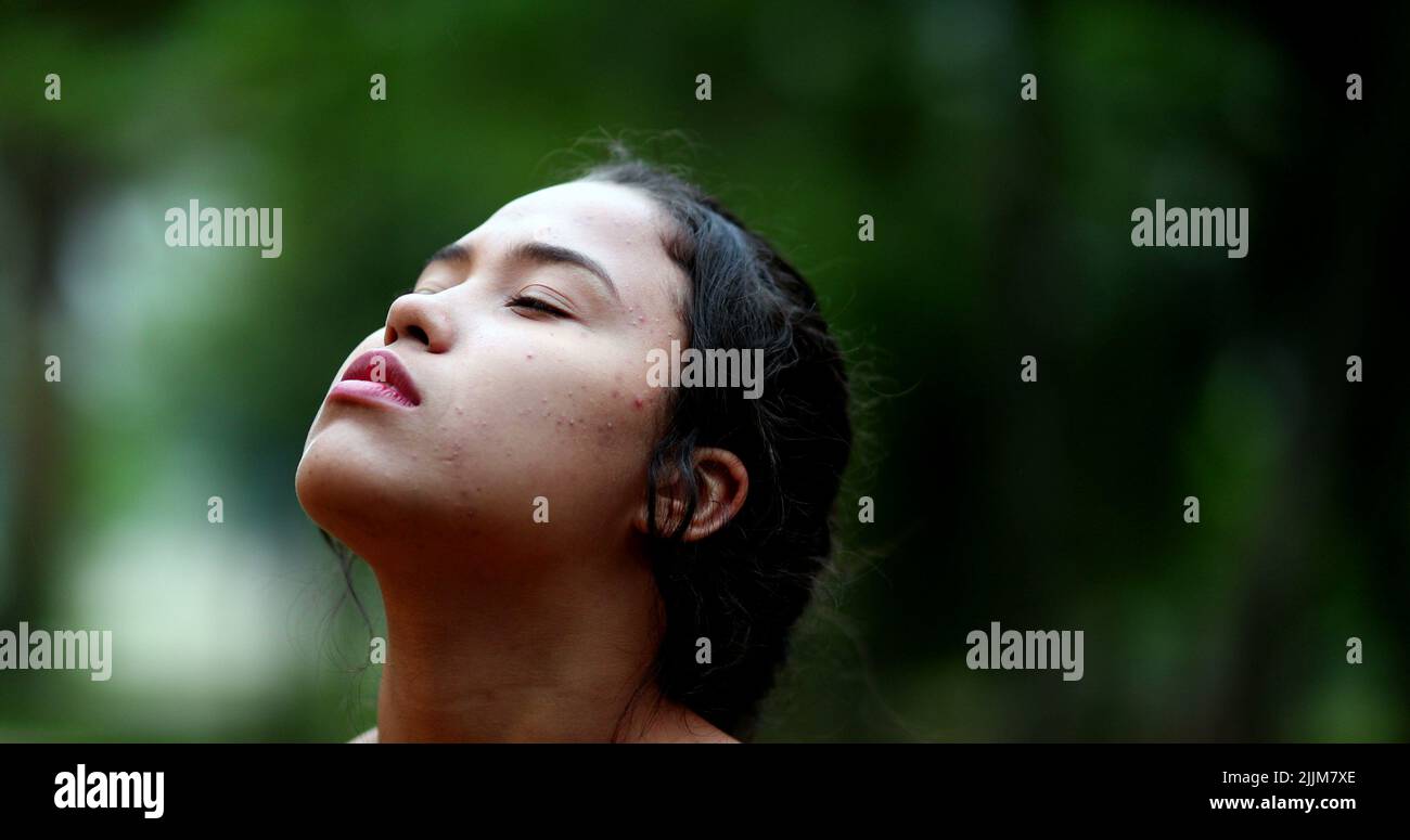 Contemplative young woman closing eyes in meditation. Close-up girl ...