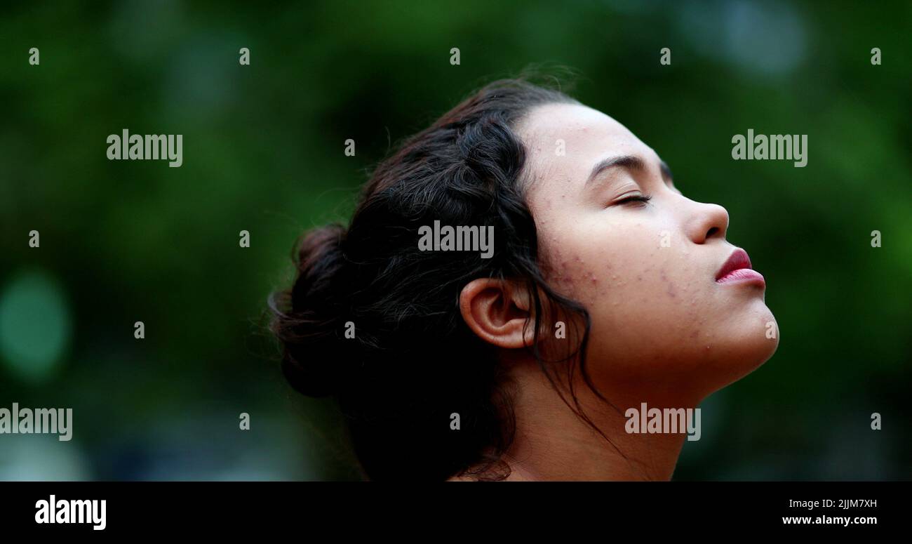 Contemplative young woman closing eyes in meditation. Close-up girl ...