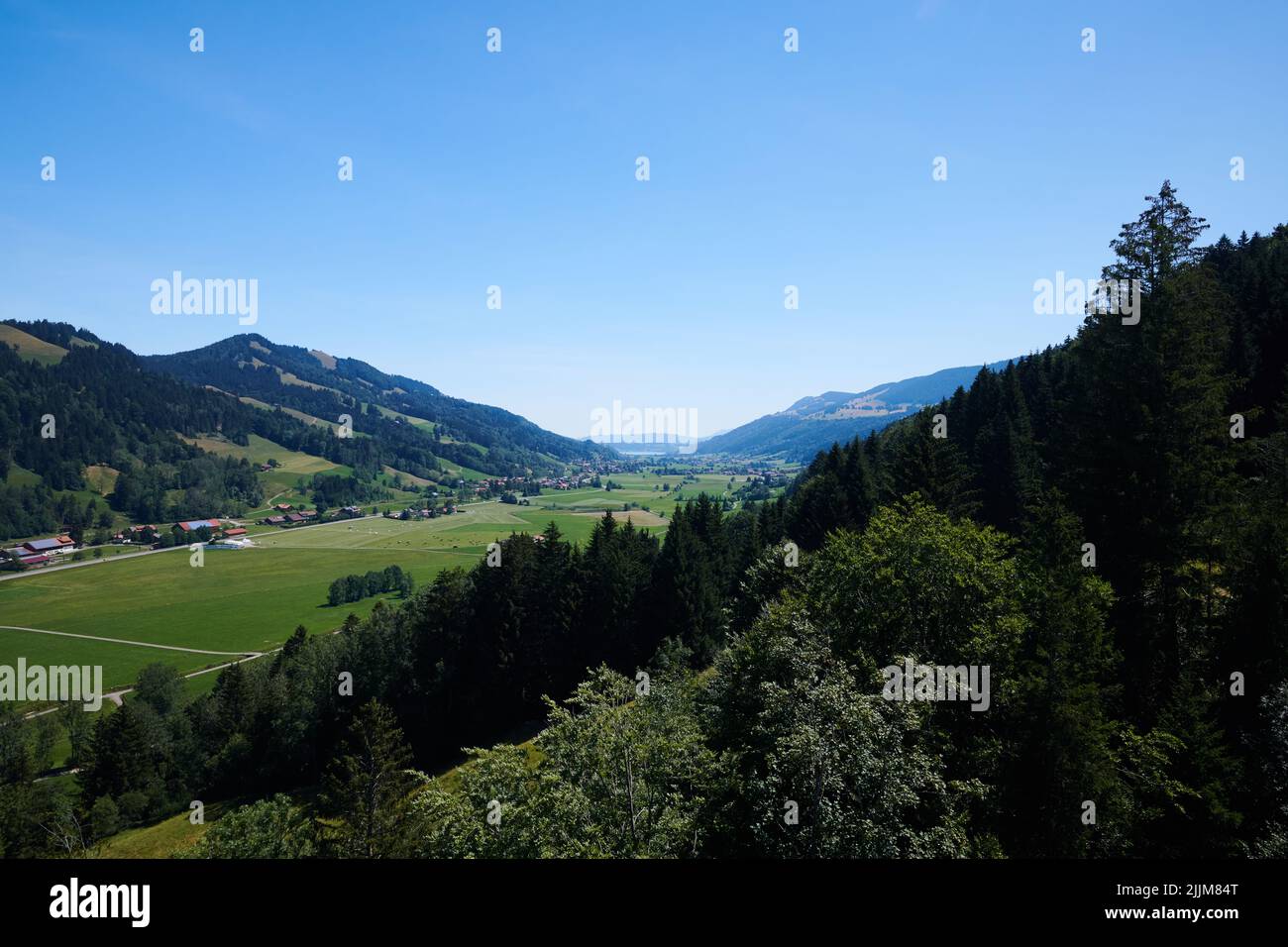 The Bavarian Alps and hills in summer sunshine are green and stunningly ...