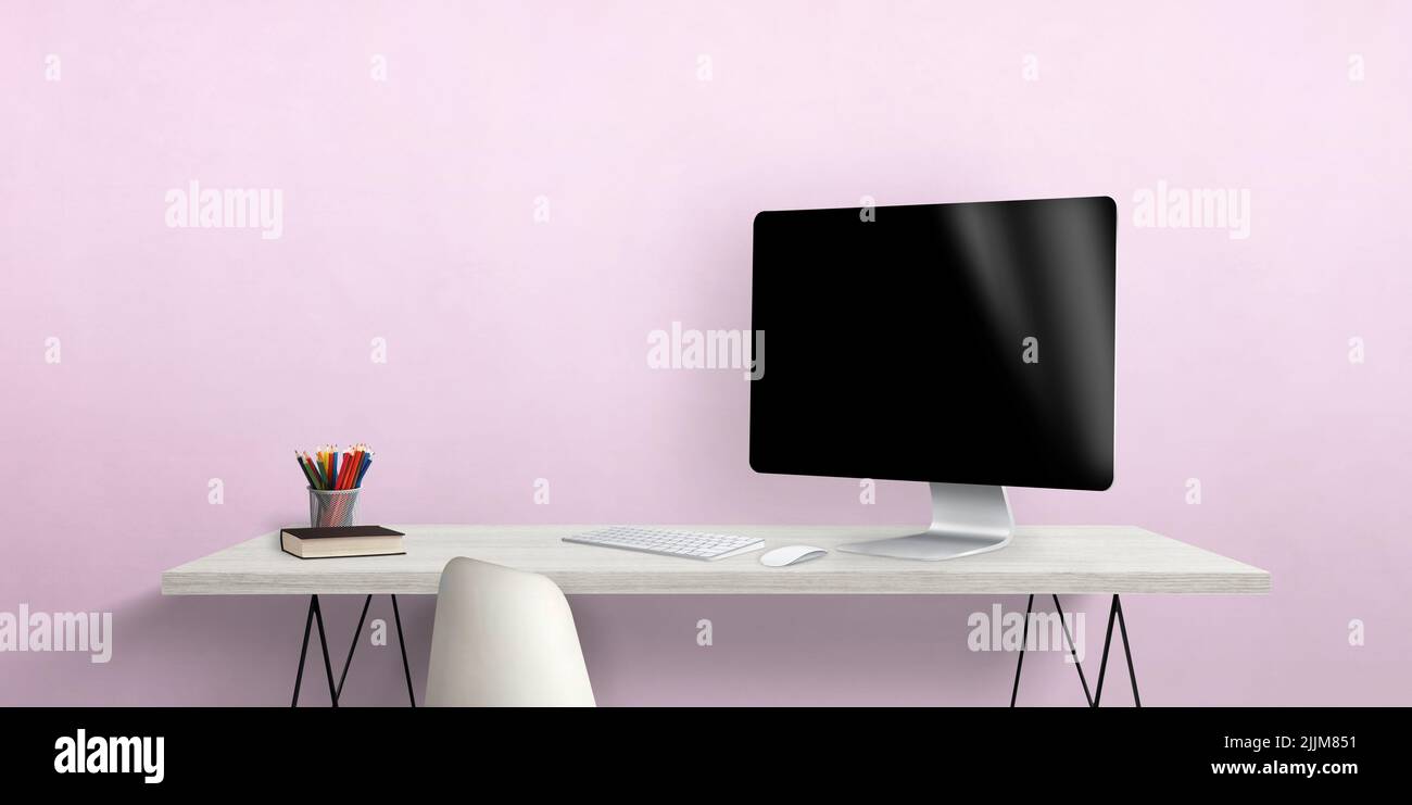 Blank computer display on work desk with pens and book beside. Pink ...