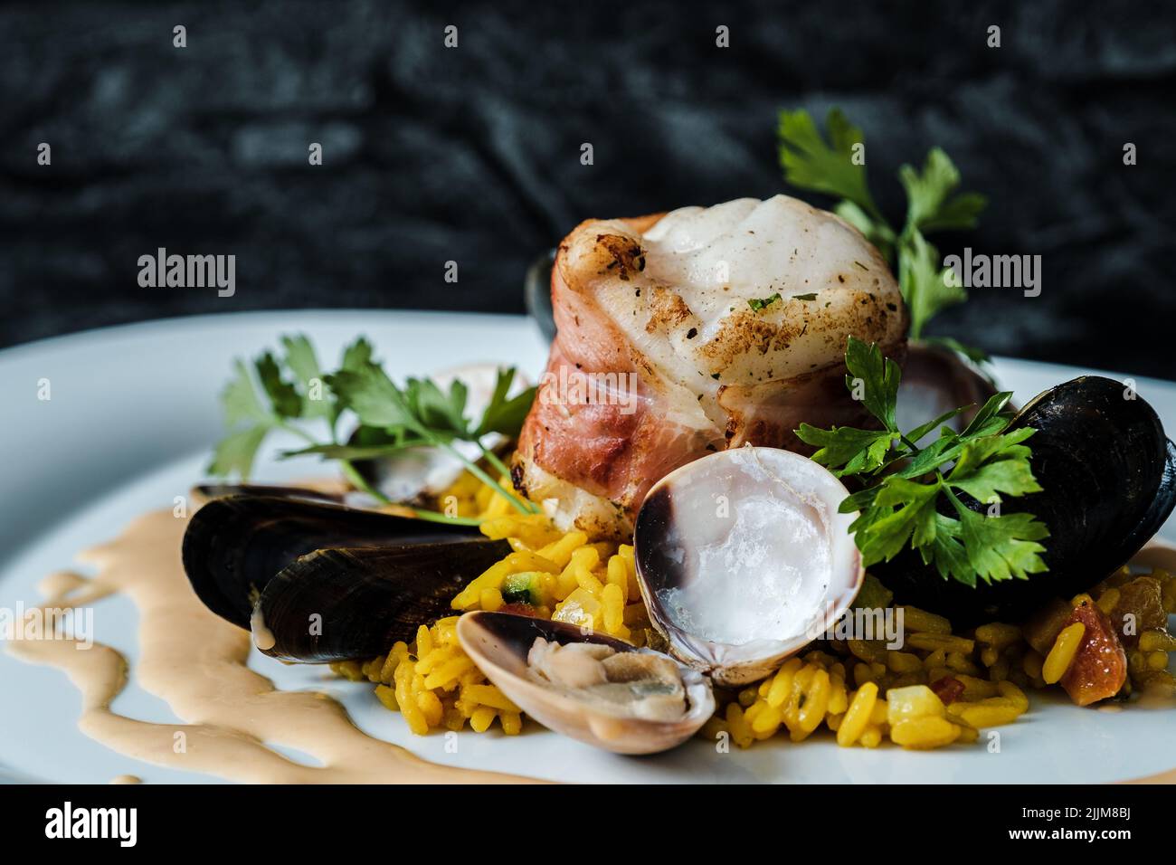 A serving of fried sea devil with mussels on vegetable rice Stock Photo ...