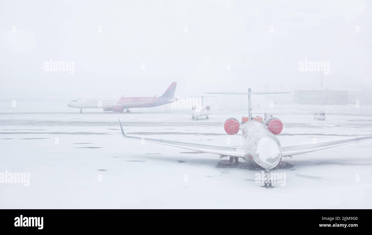 Snow covered commercial plane at the airport. Close-up of the plane ...