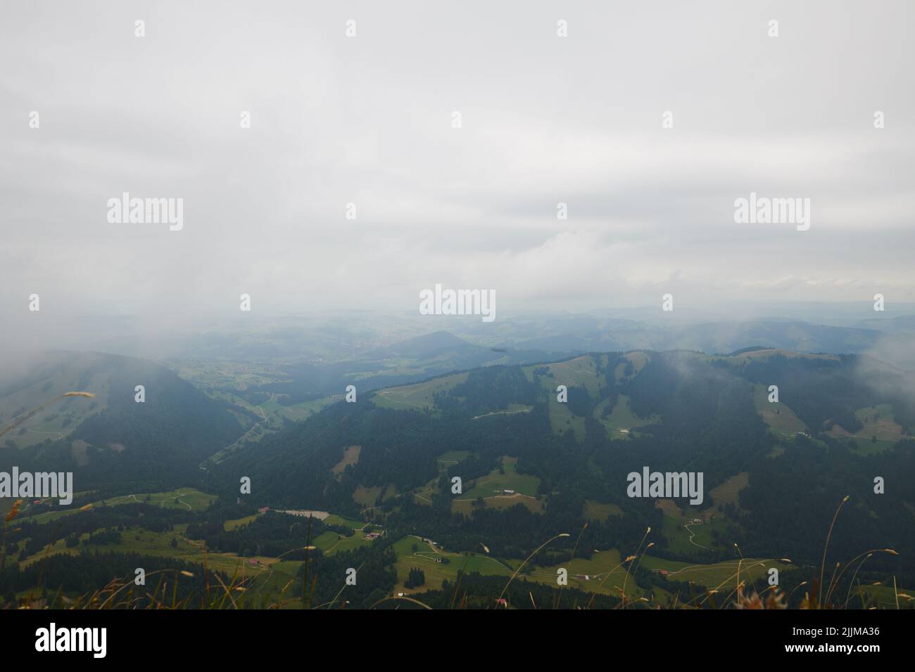 Mist on a mountain top slowly clearing in the Bavarian Alps Stock Photo ...