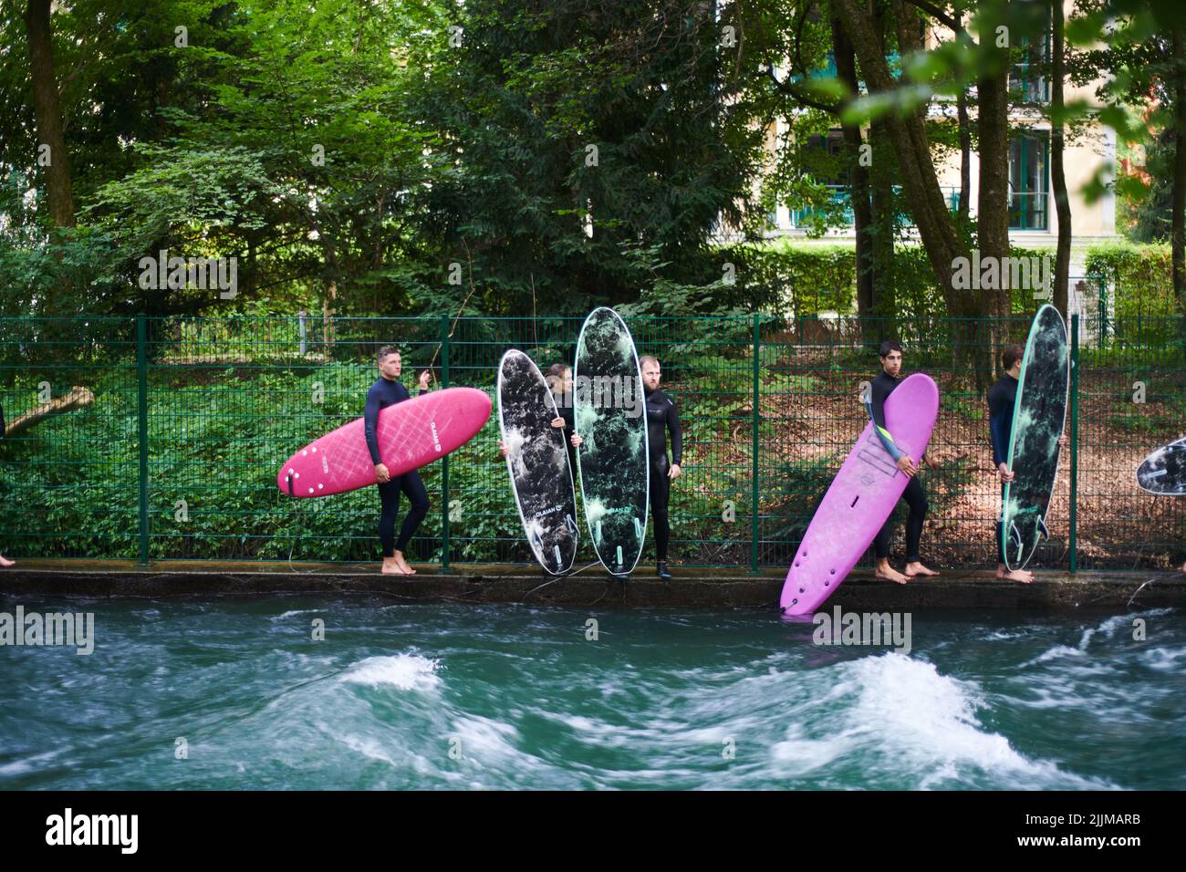 Local youth enjoying the surf in the river in the city centre of Munich ...