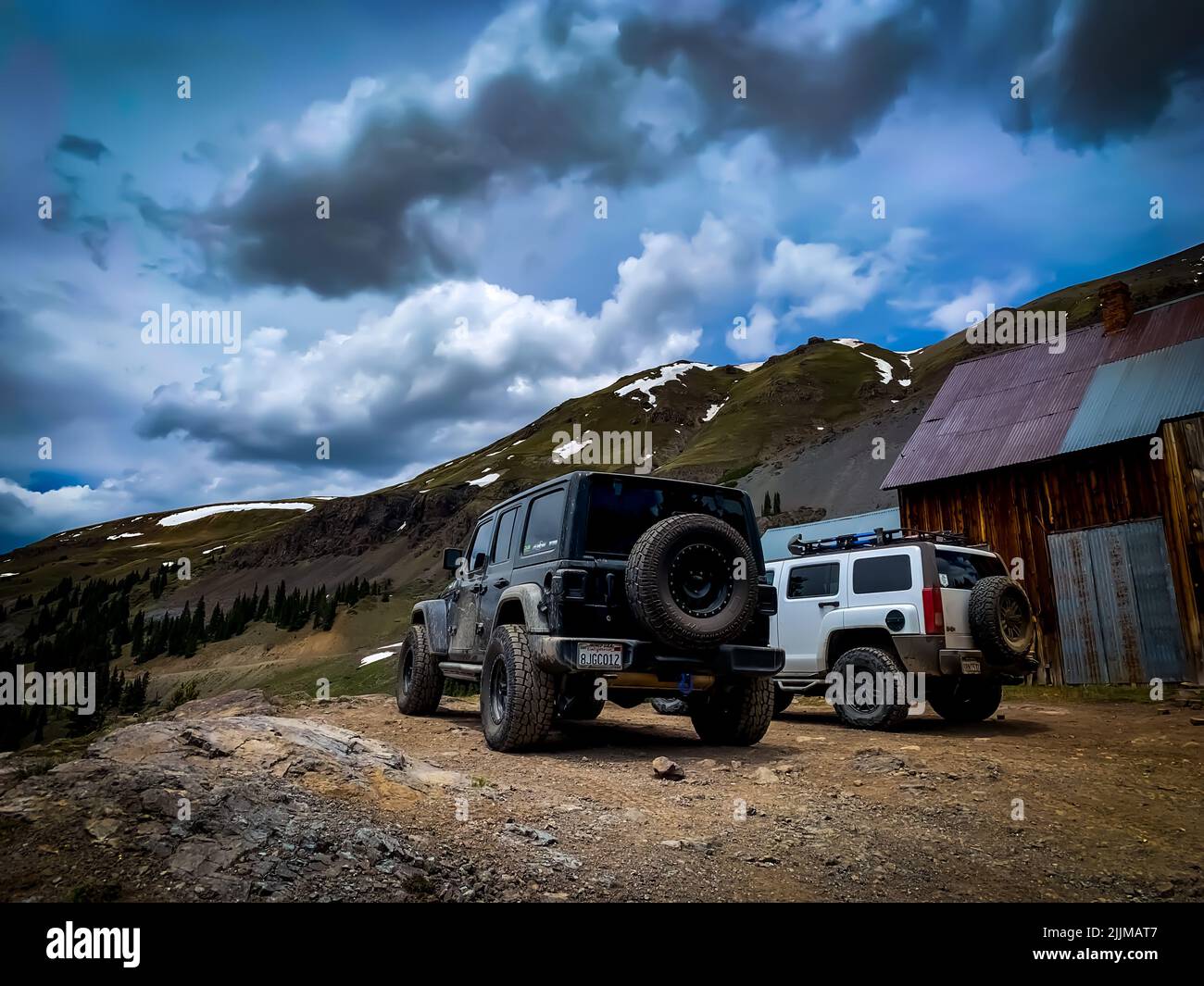 A back view of a Jeep Wrangler and a Hummer H3 on a rocky road, Ouray ...