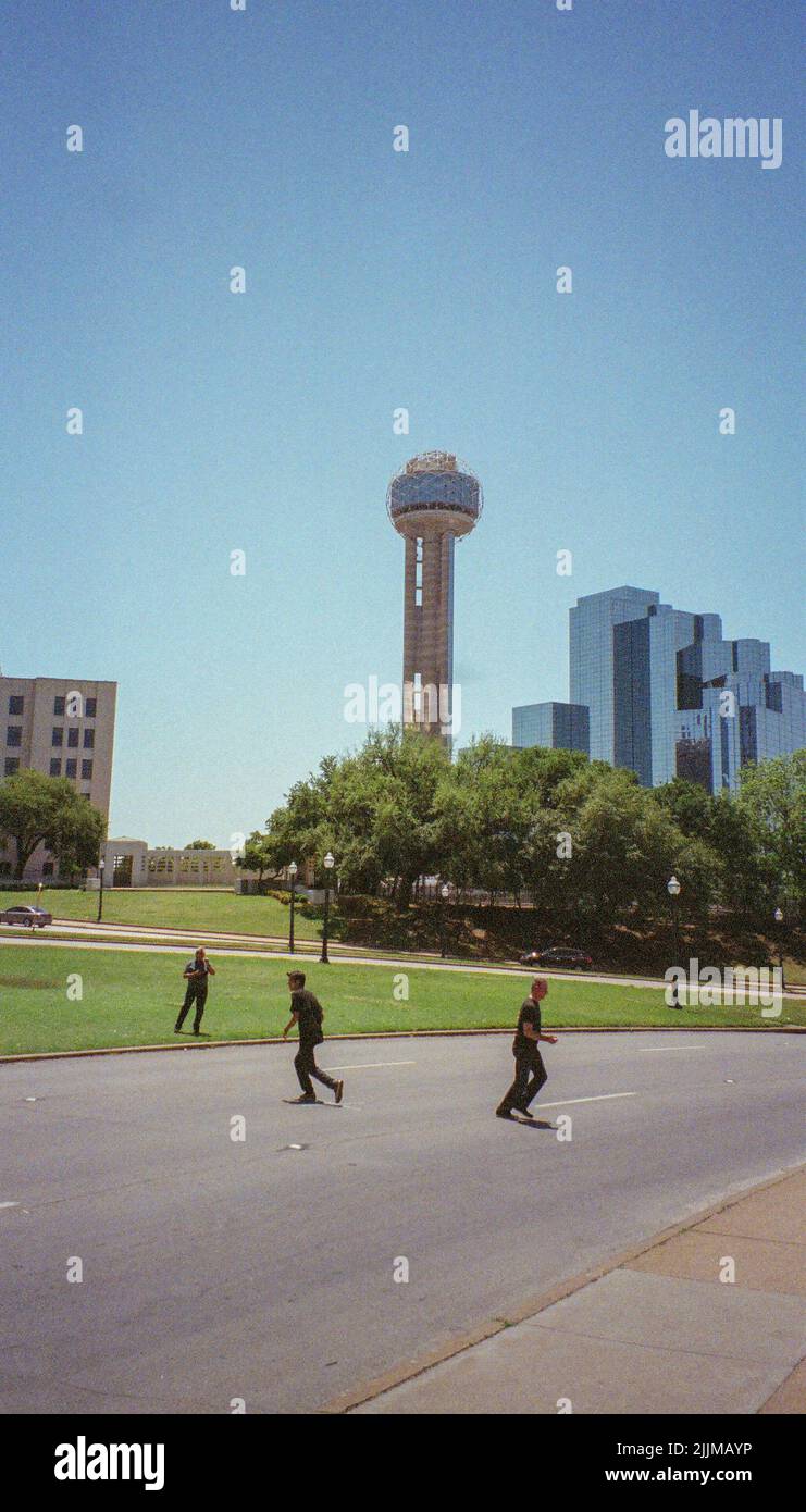 A vertical shot of people on a street with the Reunion Tower across ...
