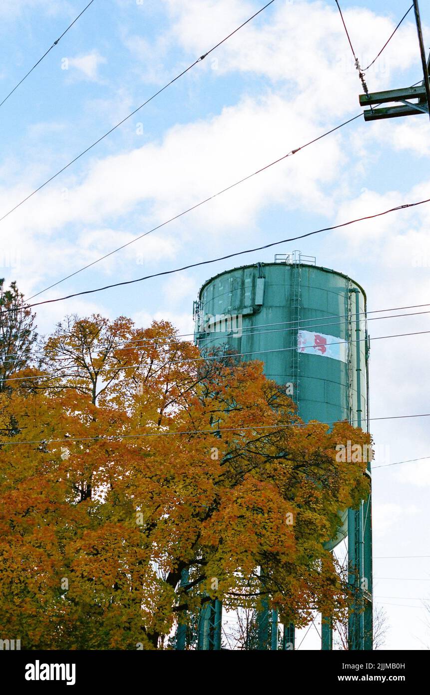 A vertical shot of a large green water tower by the Sabin Hydro Park ...
